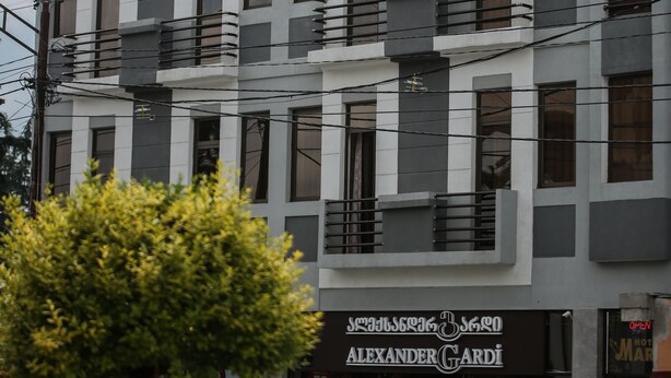Um hotel chamado 'Hotel Mars' com fachada moderna, várias varandas e uma fachada visível com o nome 'Alexander Gardi'.