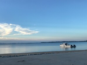 Um barco atracado em águas calmas sob um céu limpo e terra distante.