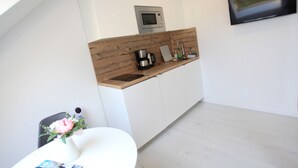 Uma cozinha moderna com micro-ondas embutido, máquina de café e pia.