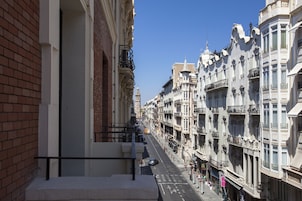 Vista da rua com uma fileira de edifícios com fachadas e varandas elaboradas.