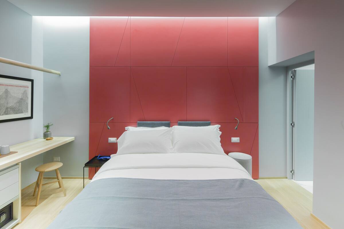 Quarto moderno com cama, escrivaninha e cadeira.