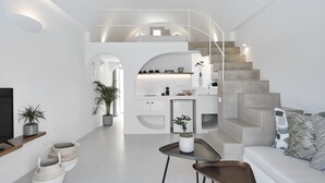 Um interior moderno com cozinha, sala de jantar e escadaria.