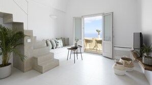 Uma sala de estar moderna com escada, área de refeições e vista para o mar.