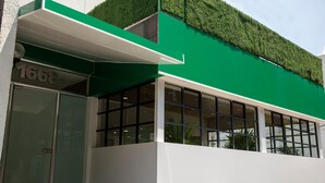 Um edifício moderno com fachada verde, grandes janelas e o número 1668 visível.