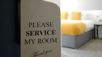 Porta de quarto de hotel com um aviso que diz "POR FAVOR, LIMPAR MEU QUARTO. Obrigado".