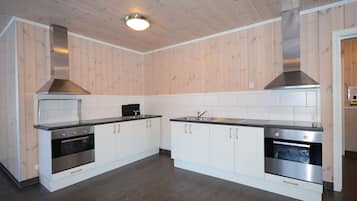 Um frigorífico, um forno, uma placa de cozinha, uma cafeteira/bule