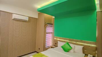 Quarto de hotel com cama, mesa de cabeceira e aparelho de ar condicionado.