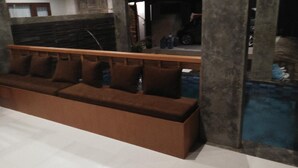 Um interior moderno com um sofá marrom e um pilar de pedra.