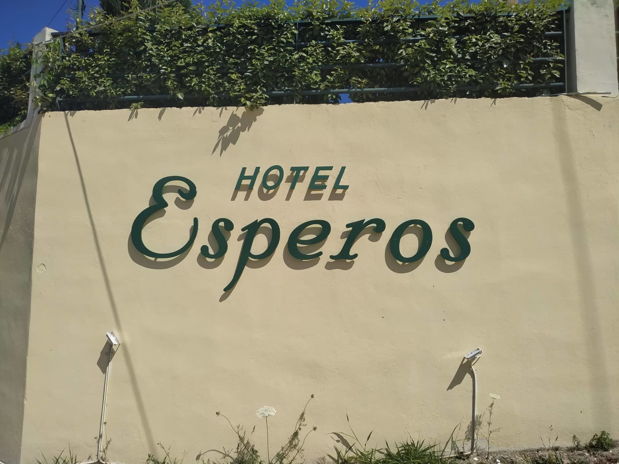 Parede com o texto "HOTEL Esperos" em letras grandes e negrito.