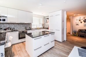 Apartamento, 4 quartos | Cozinha privada | Geladeira grande, micro-ondas, fogão, cooktop