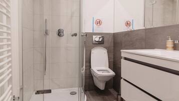 Apartamento luxo, vista para o pátio | Comodidades do banheiro | Chuveiro, chuveiro com efeito de chuva, secador de cabelo, chinelos