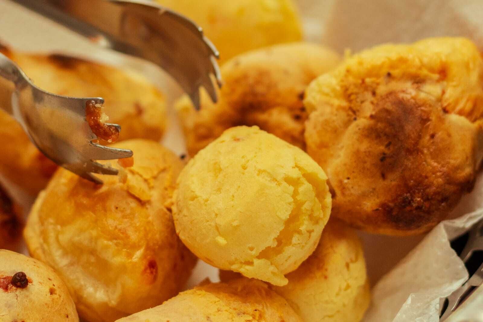 Close-up de alimentos, possivelmente lanches ou sobremesas, com um utensílio em primeiro plano.