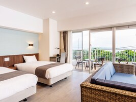 Quarto de hotel com duas camas, uma varanda com mobiliário de vime e vista para o verde.