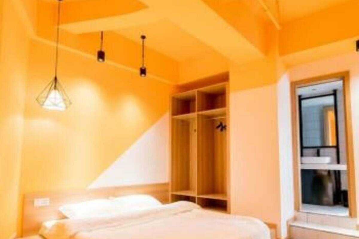 Quarto com uma cama, um guarda-roupa e uma janela.