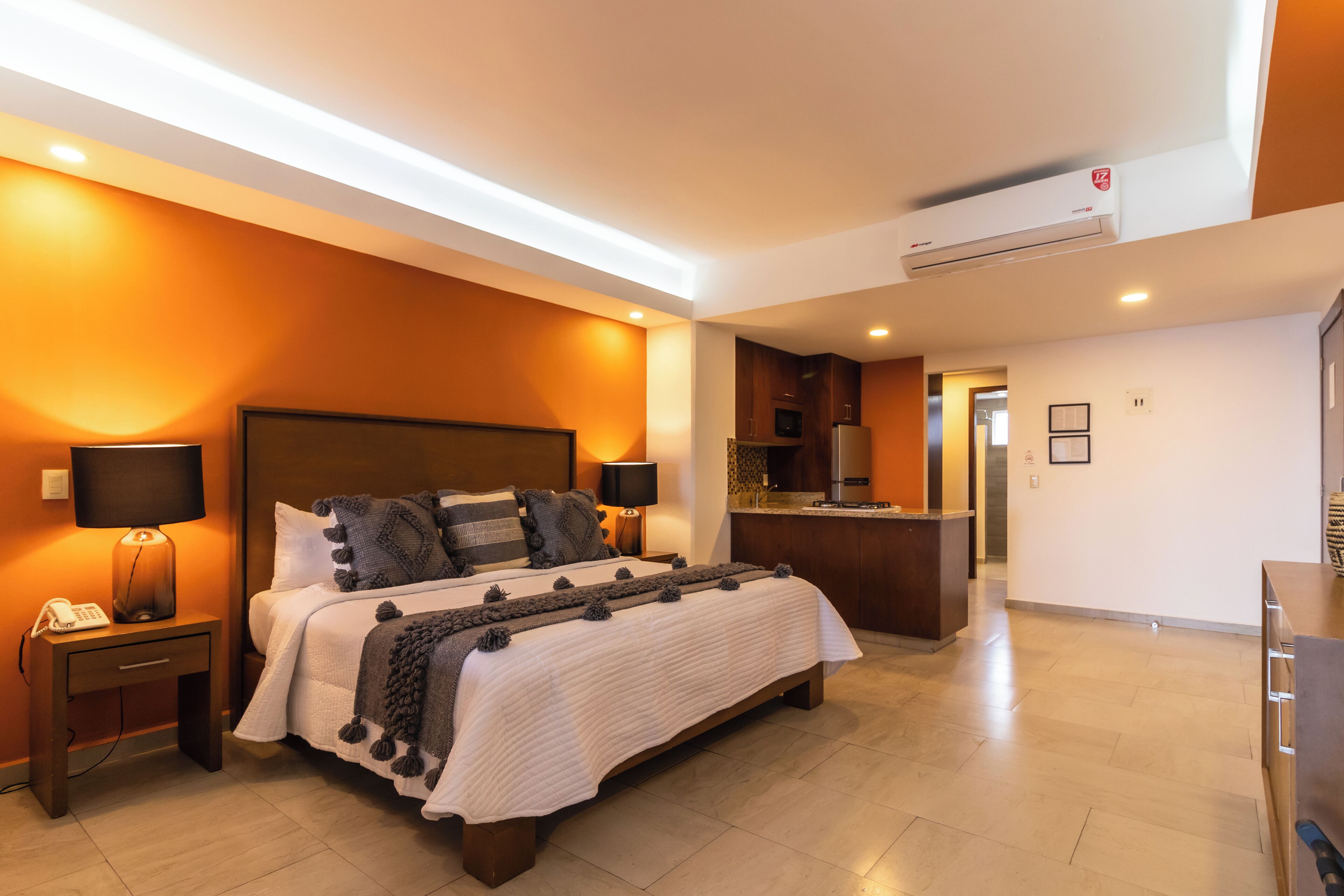 Quarto moderno com uma cama grande, luminárias laterais, mesa de cabeceira e um espaço de trabalho embutido.