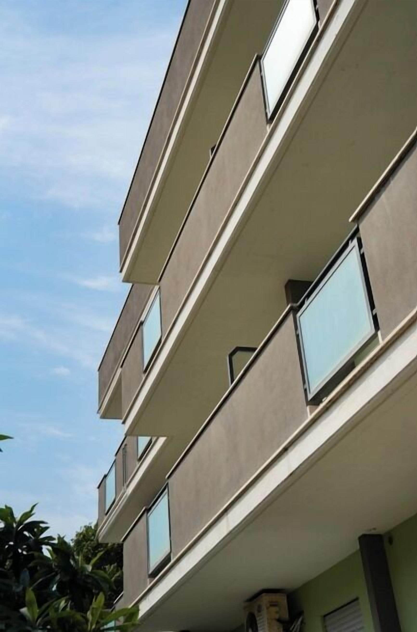 Um edifício com várias andares, varandas e janelas.