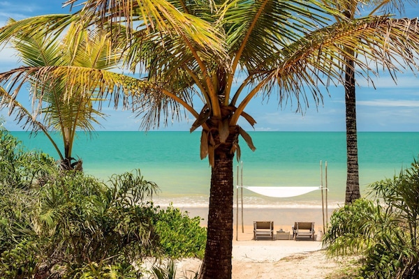 Perto da praia, areia branca, barracas de praia de cortesia