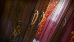 Uma porta de madeira com puxadores ornamentados e um emblema decorativo.