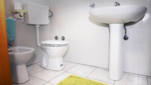 Casa de banho com sanita, bidé e lavatório.