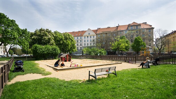 Um parque com um parquinho, um baloiço e um espaço de areia.