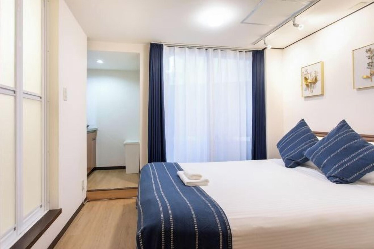 Quarto de hotel com cama, banheiro e vista para o exterior.