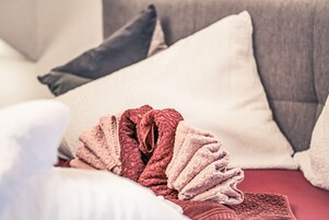 Uma cama com cobertor e travesseiros em um quarto de hotel.