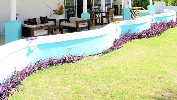 Uma casa moderna de dois andares com piscina, área de estar externa e varanda coberta.