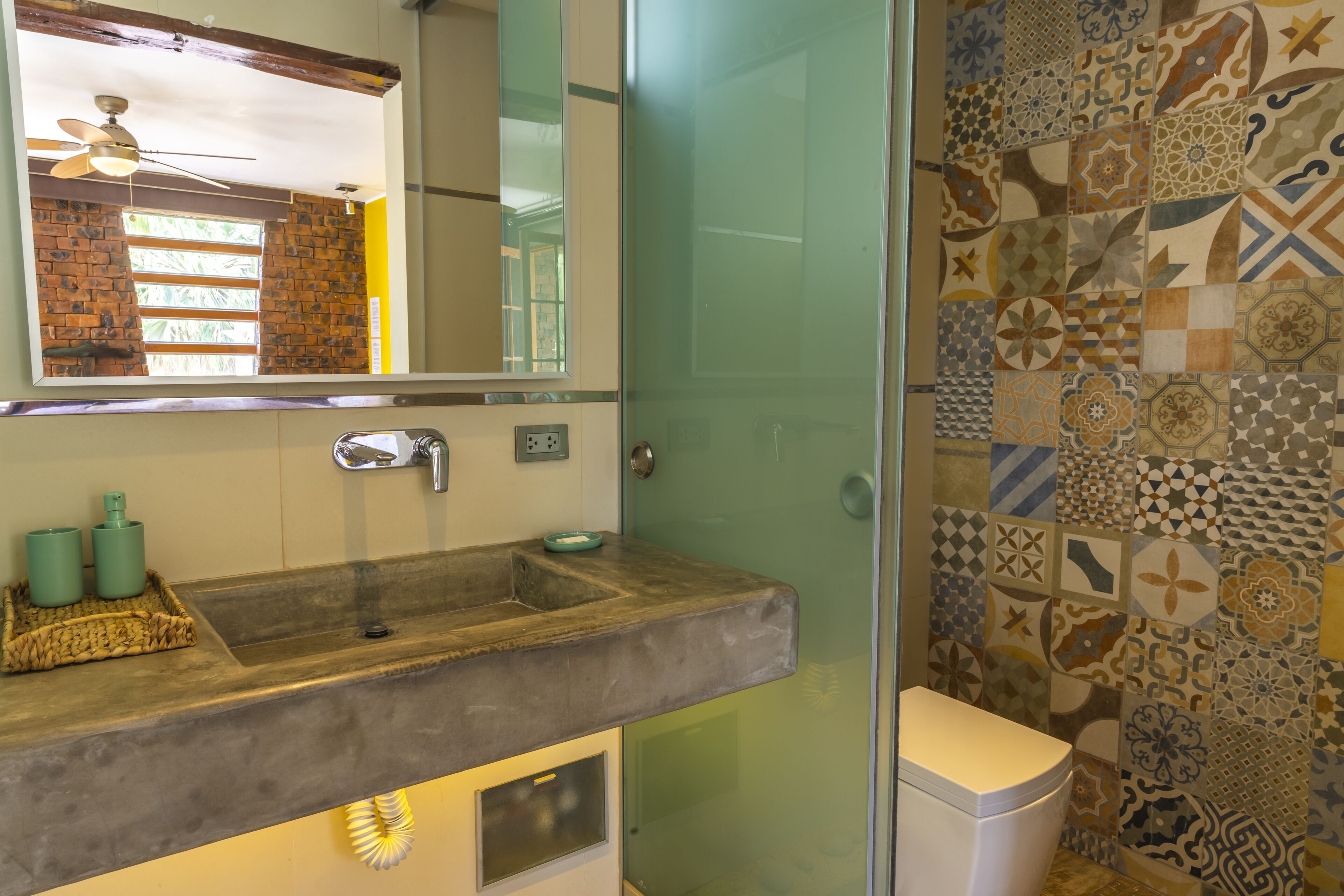 Casa de banho com lavatório moderno, cabine de chuveiro em vidro e sanita.