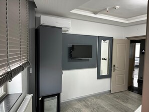Quarto Triplo Básico, Vista para a cidade | Sala de estar | Televisor de ecrã plano de 37 polegadas com canais de TV premium 