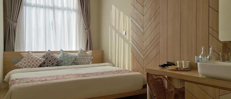Quarto de hotel com uma cama, uma escrivaninha e uma cadeira.