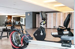Academia com máquinas de cardio, incluindo uma máquina de remo e uma elíptica.