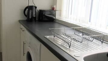 Apartamento Básico, 4 quartos | Cozinha privada | Um frigorífico/congelador grande, um micro-ondas, um forno