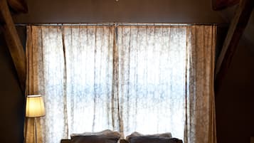 Quarto com cama grande, lustre, cortinas e abajur.