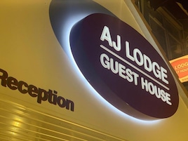 Placa para a AJ Lodge Guest House, indicando a área de recepção.