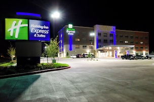 Um hotel Holiday Inn Express & Suites com estacionamento e entrada do edifício.