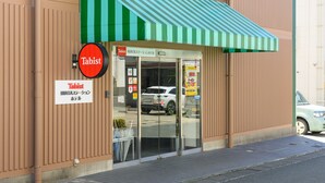 Um edifício com toldo verde listrado e uma placa com a inscrição "Tabist".
