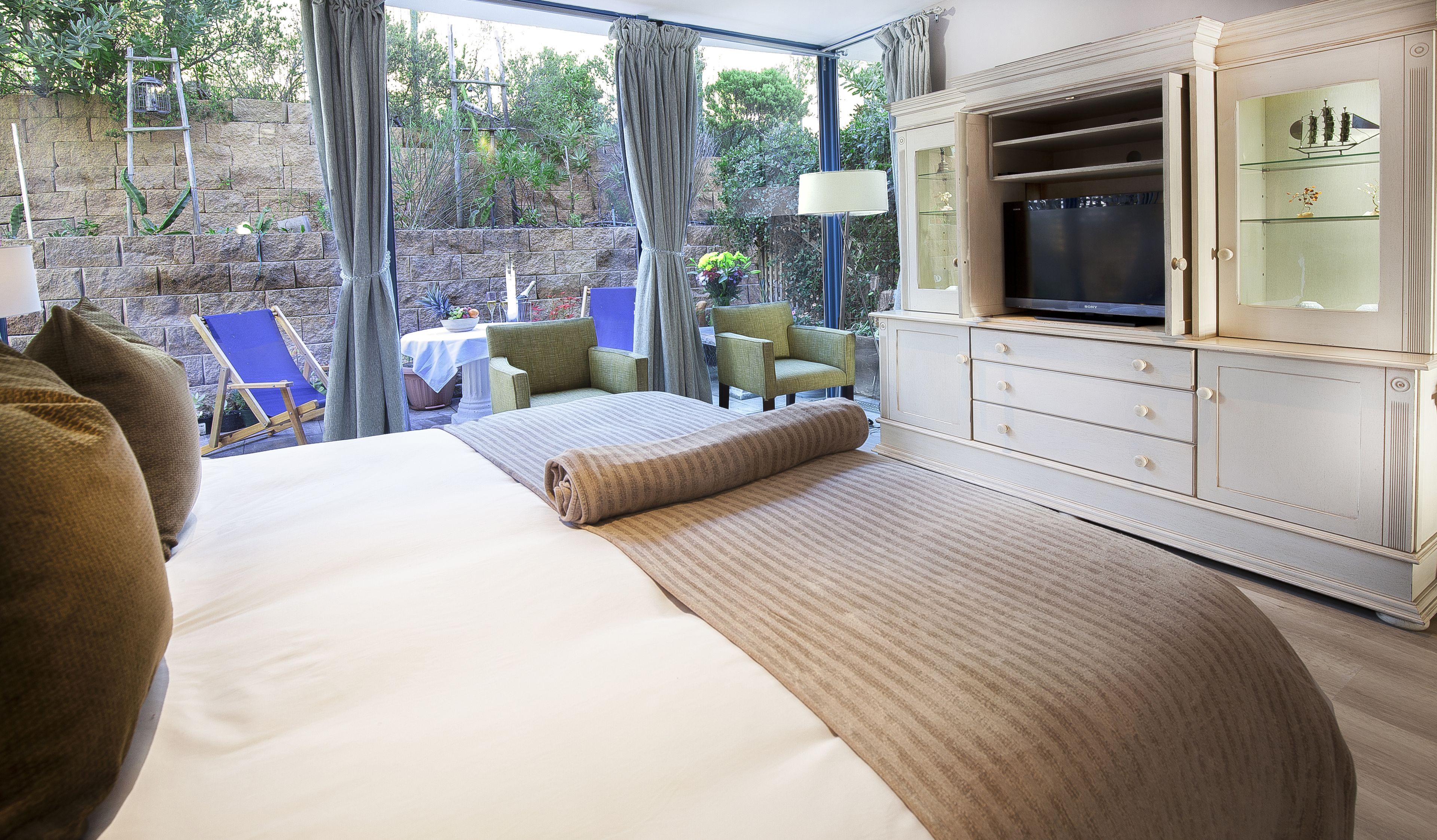 Quarto com uma cama grande, uma televisão e vista para o exterior.