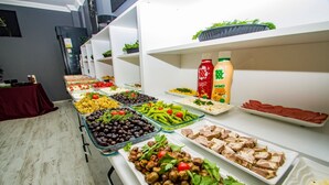 Um buffet com diversos alimentos e acompanhamentos.