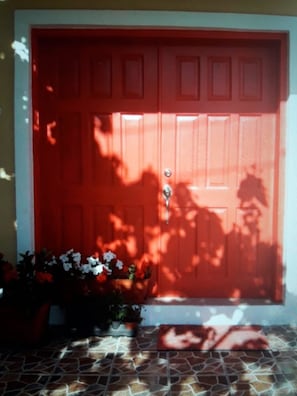 Uma porta vermelha com um pequeno alpendre.