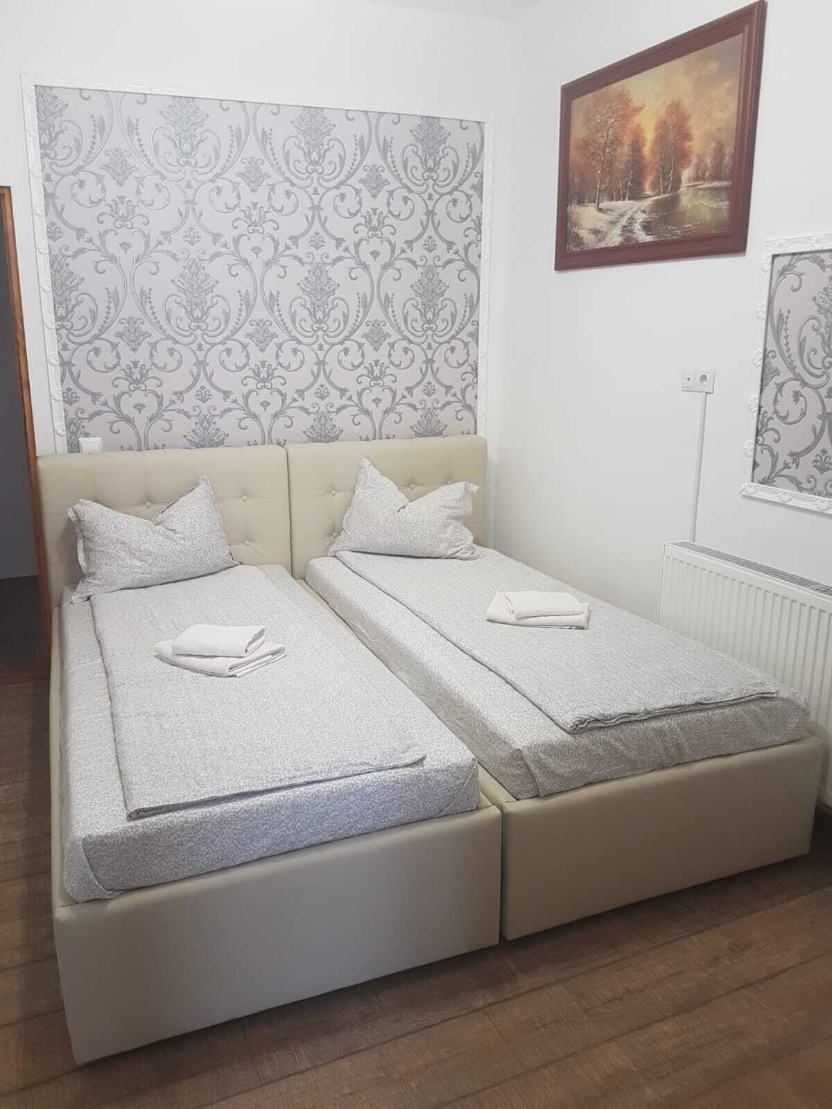 Cama de casal com cabeceira, duas almofadas e um cobertor.