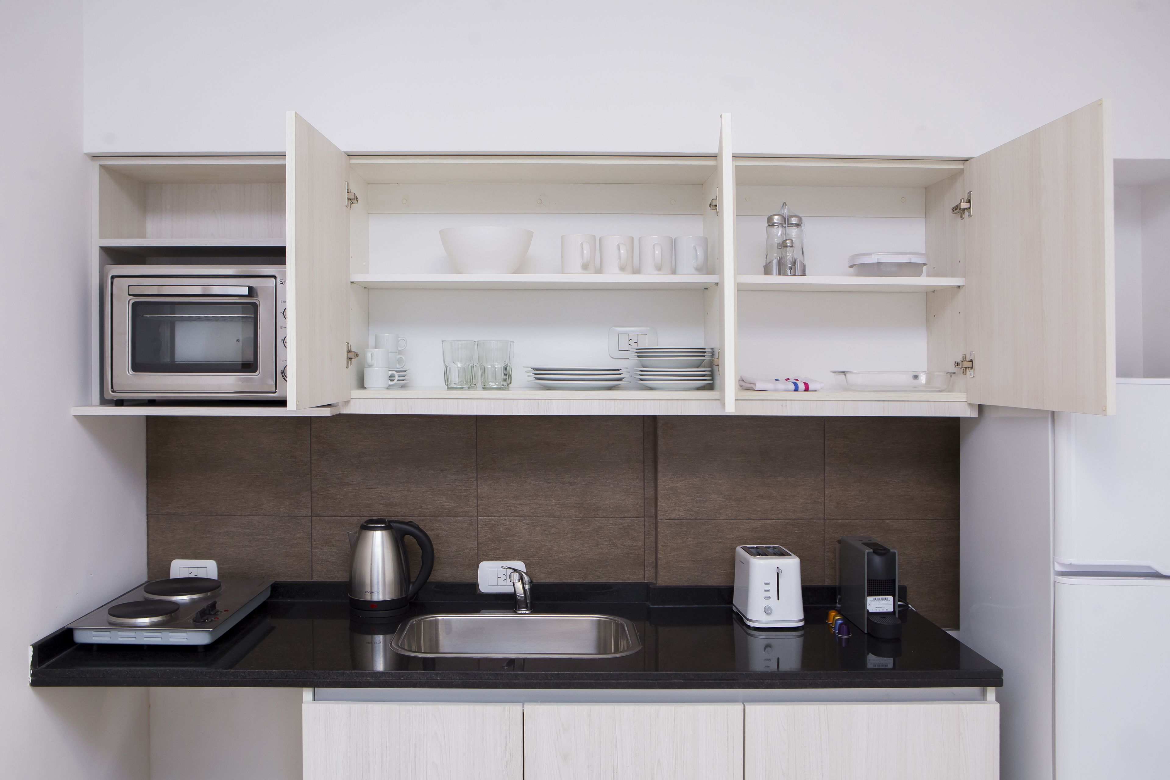 Um frigorífico, uma placa de cozinha, utensílios de cozinha 