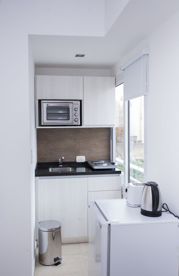 Apartamento Standard | Kitchenette privada | Um frigorífico, uma placa de cozinha, utensílios de cozinha