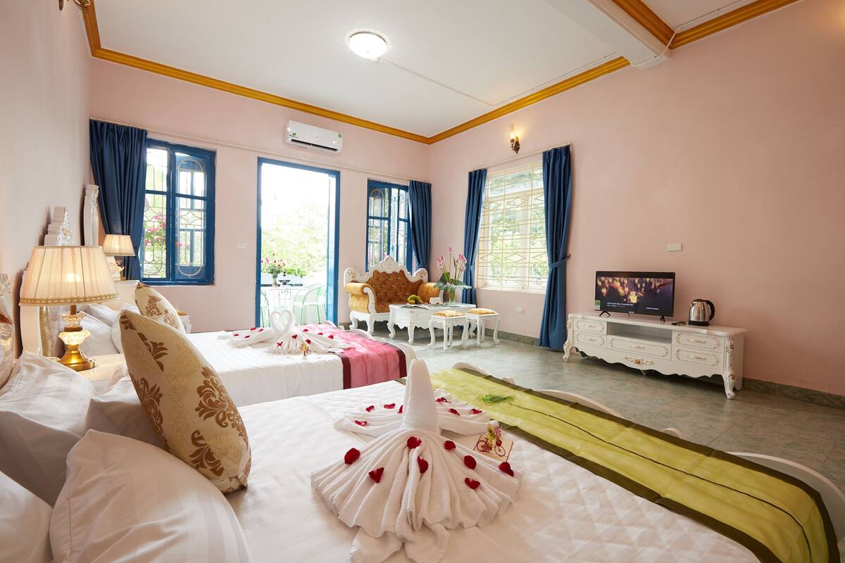 Quarto de hotel com uma cama, televisão, escrivaninha e cadeira.