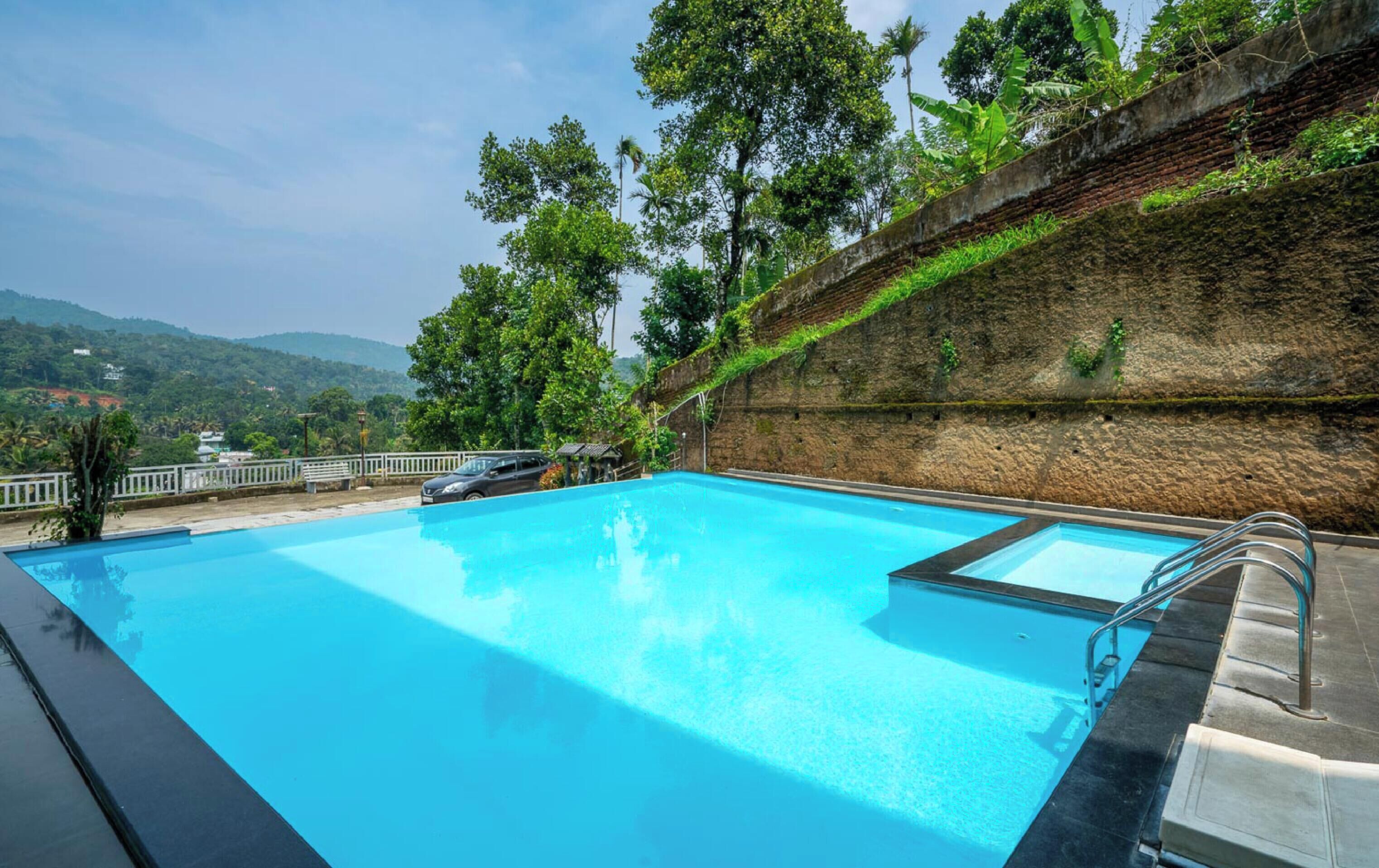 Uma piscina com vista clara da paisagem circundante, incluindo árvores e colinas ao longe.