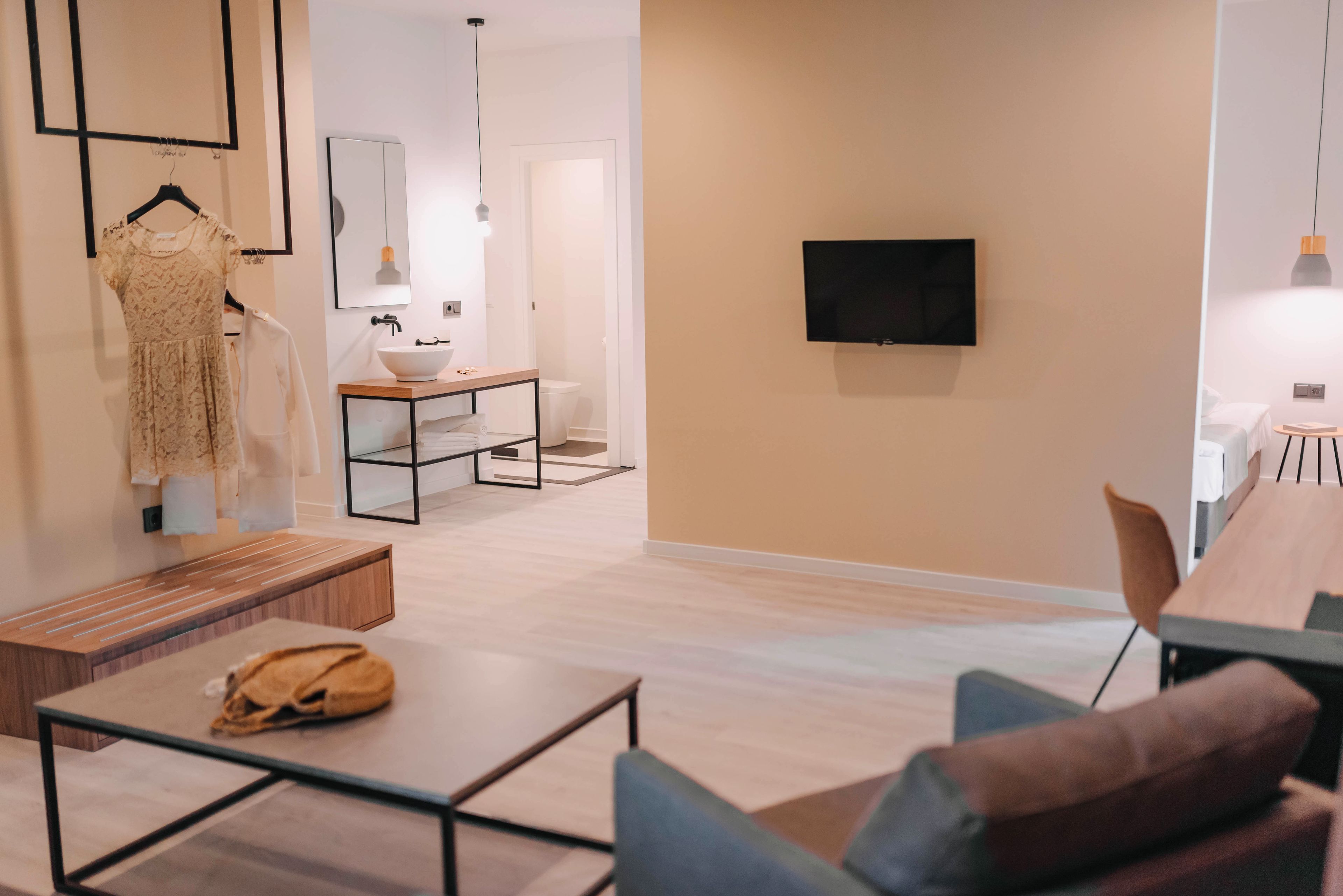 Uma sala de estar moderna com um sofá, uma mesa de centro e uma TV fixada na parede.