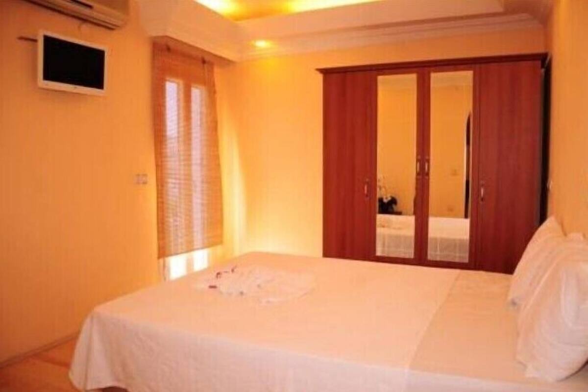 Quarto com cama, guarda-roupa e televisão.
