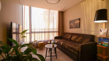 Apartamento de Luxo, vista para o mar | Sala de estar | Smart TV de 65 polegadas com canais de TV premium, televisor