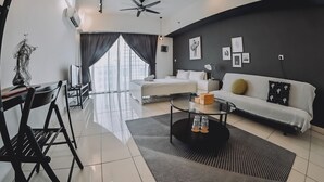 Quarto de hotel moderno com cama, sofá, mesa de centro e escrivaninha com cadeira.