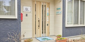 Uma porta de madeira com uma placa indicando 'TOMO OPEN' e uma pequena placa acima.
