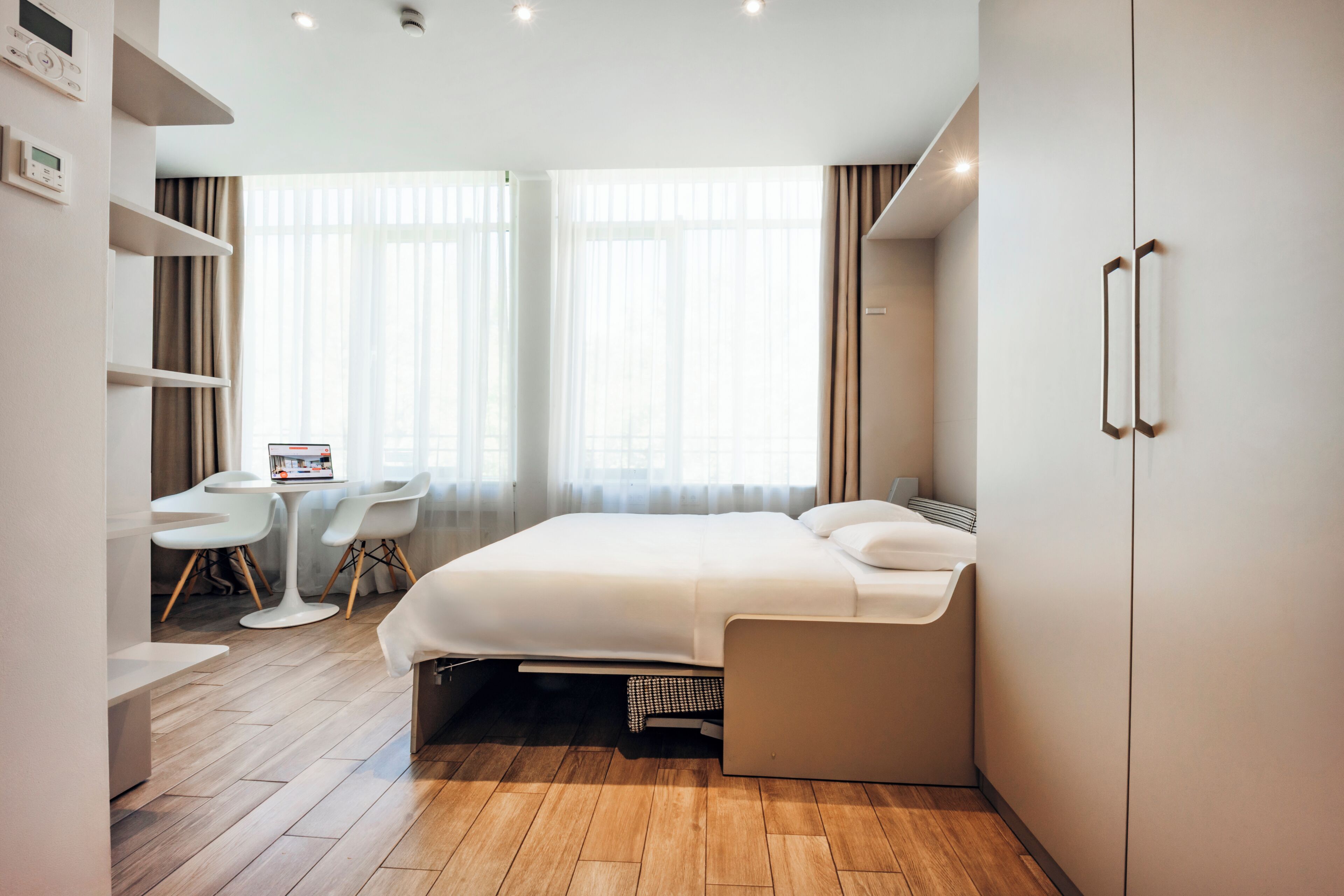 Quarto de hotel moderno com uma cama, uma escrivaninha e uma cadeira.